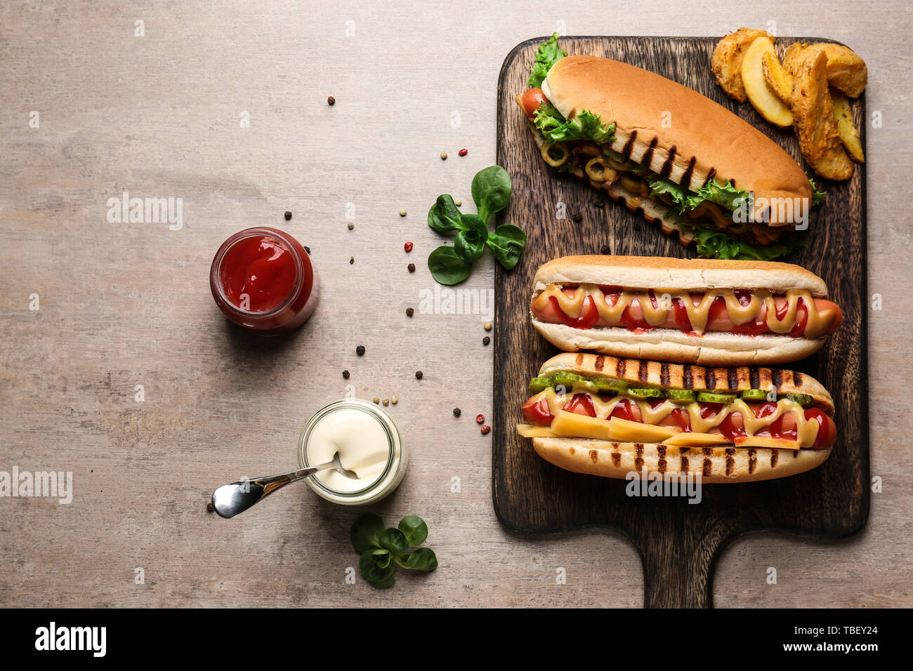 Tasty hot dogs with sauces on grey table Stock Photo - Alamy