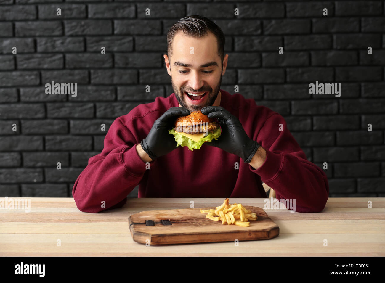 Man eating hamburger sitting table hi-res stock photography and images ...