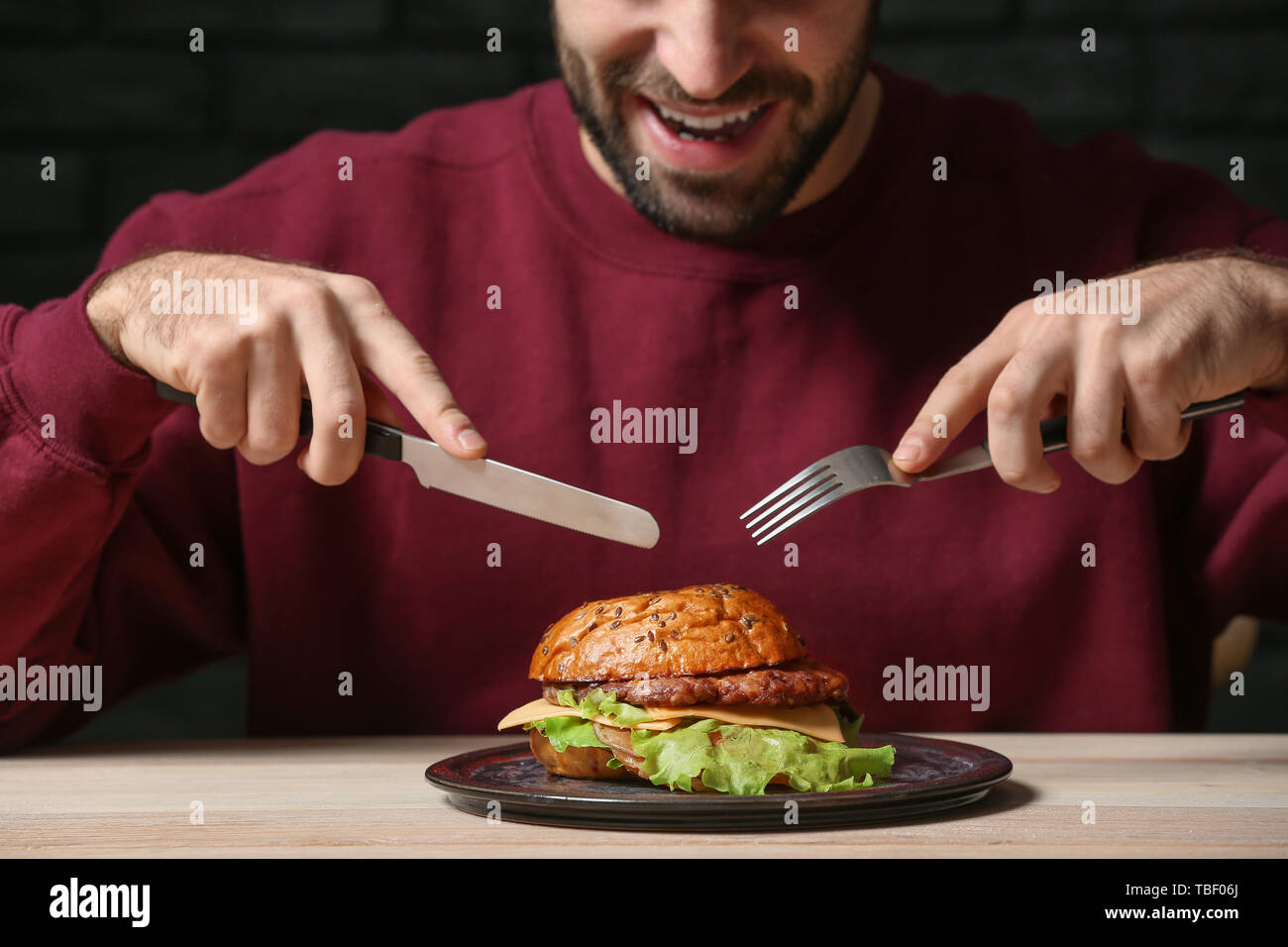 Man eating hamburger sitting table hi-res stock photography and images ...