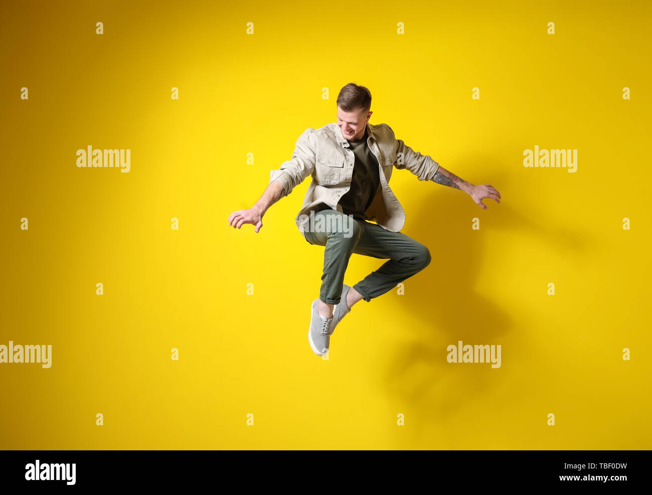 Handsome jumping man against color background Stock Photo - Alamy