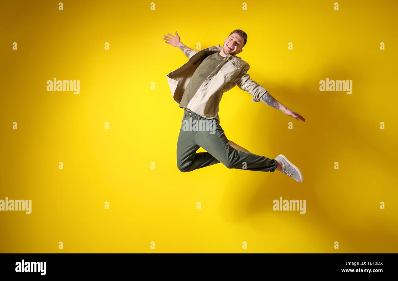 Handsome jumping man against color background Stock Photo - Alamy