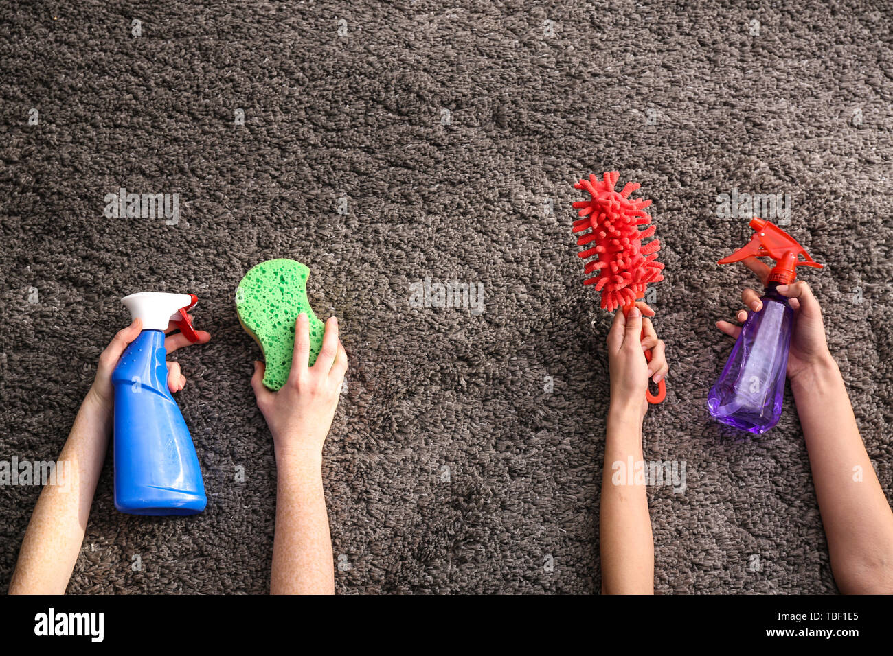 Hands with cleaning supplies on soft carpet Stock Photo - Alamy