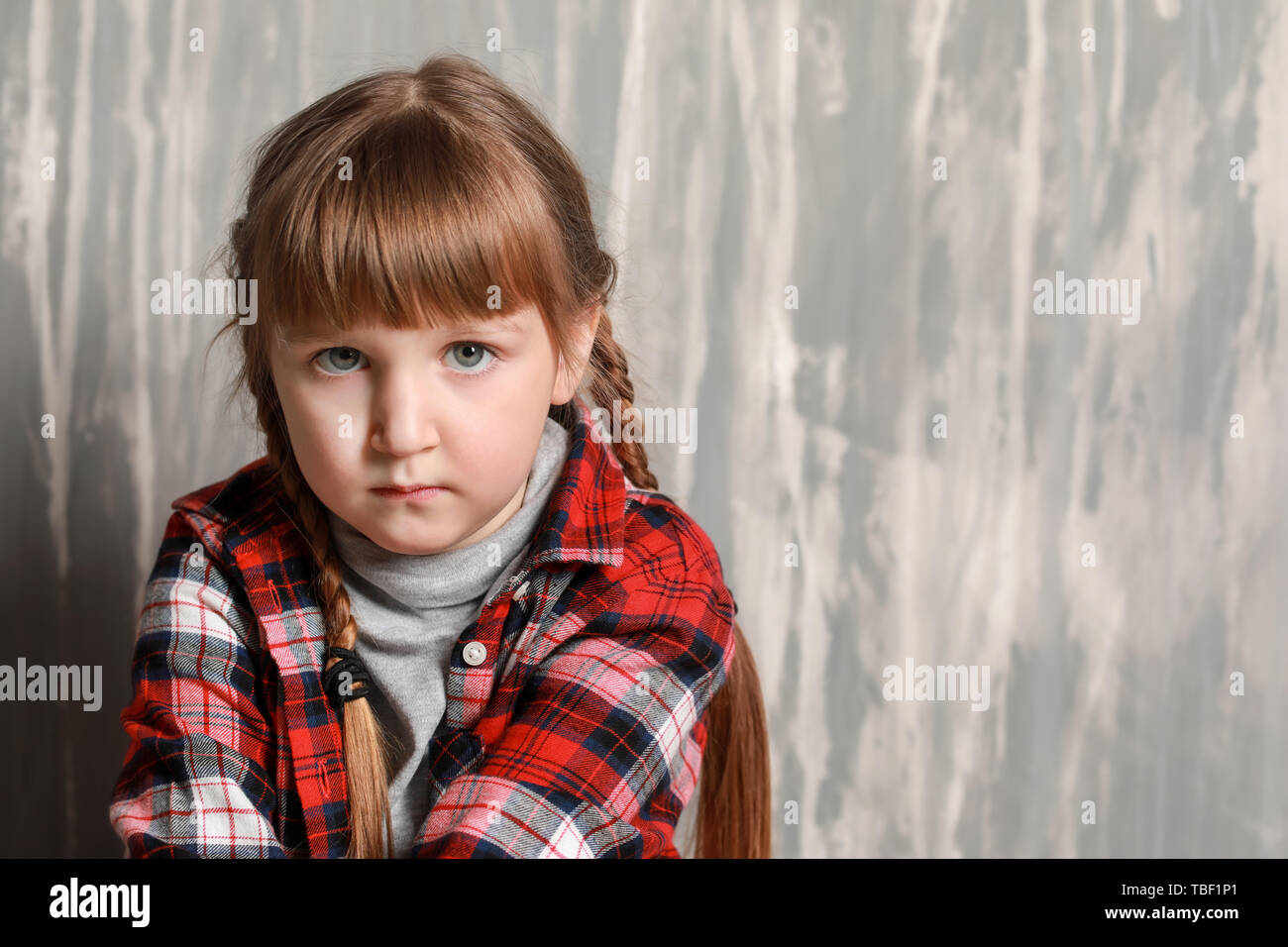 Portrait of sad little girl on grey background Stock Photo - Alamy
