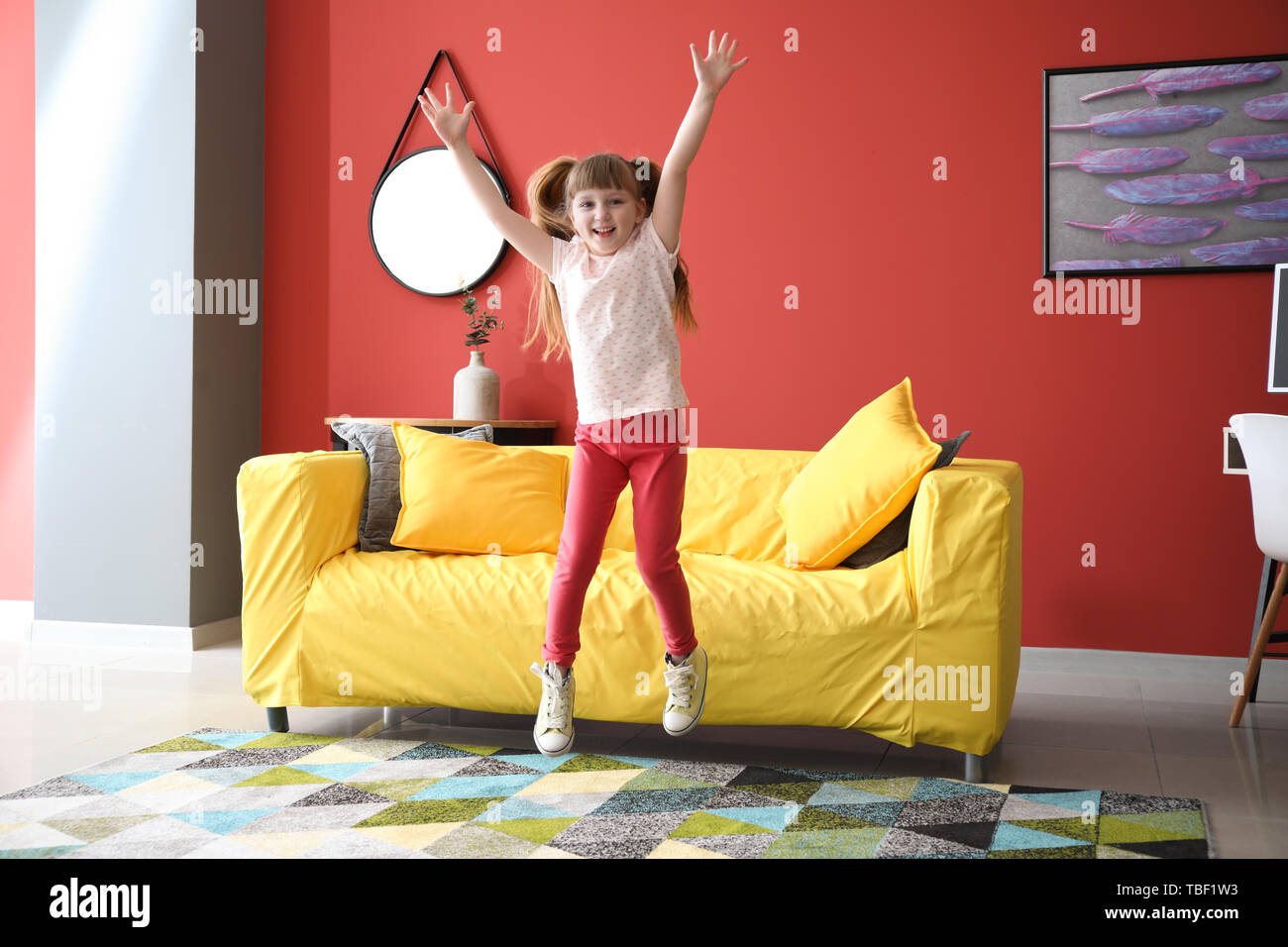 Jumping little girl at home Stock Photo - Alamy