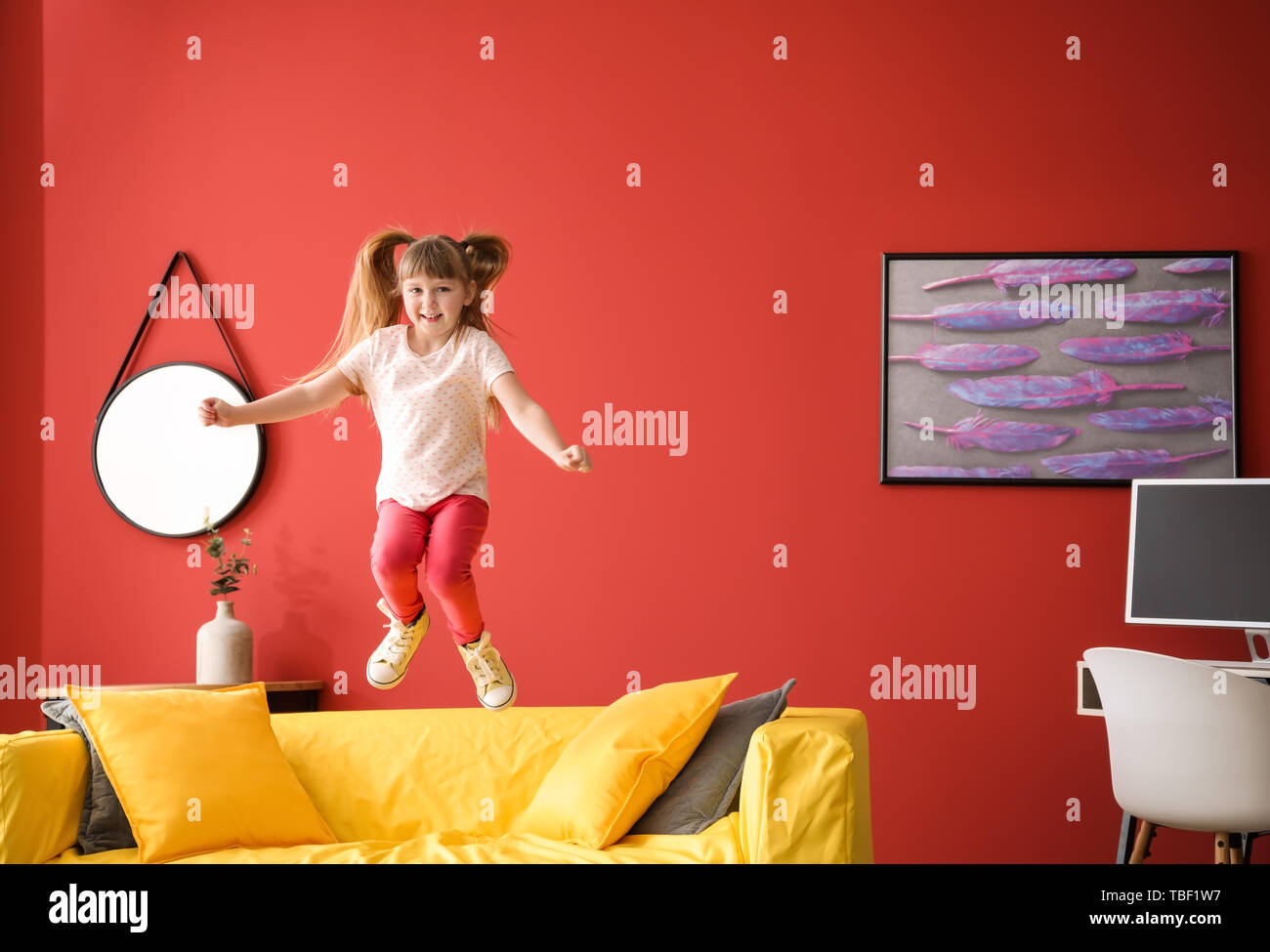 Jumping little girl at home Stock Photo - Alamy