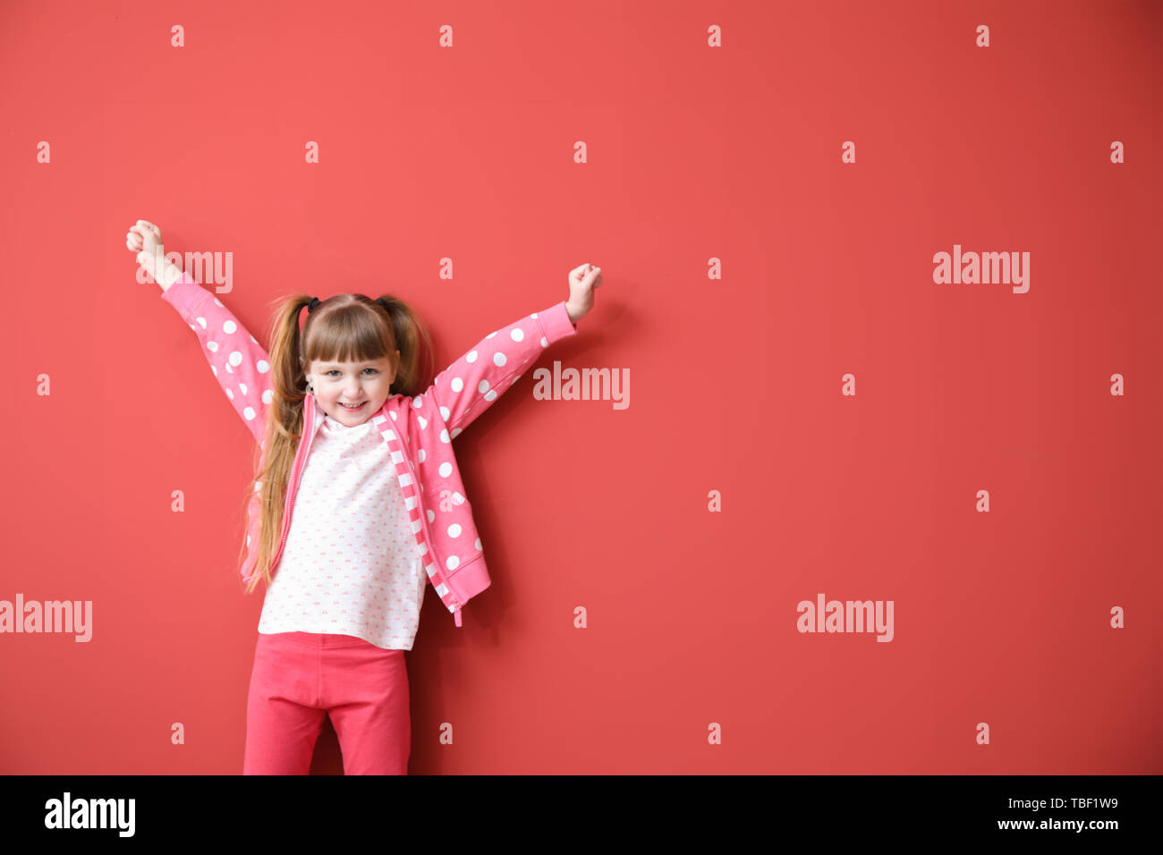 Happy little girl on color background Stock Photo - Alamy