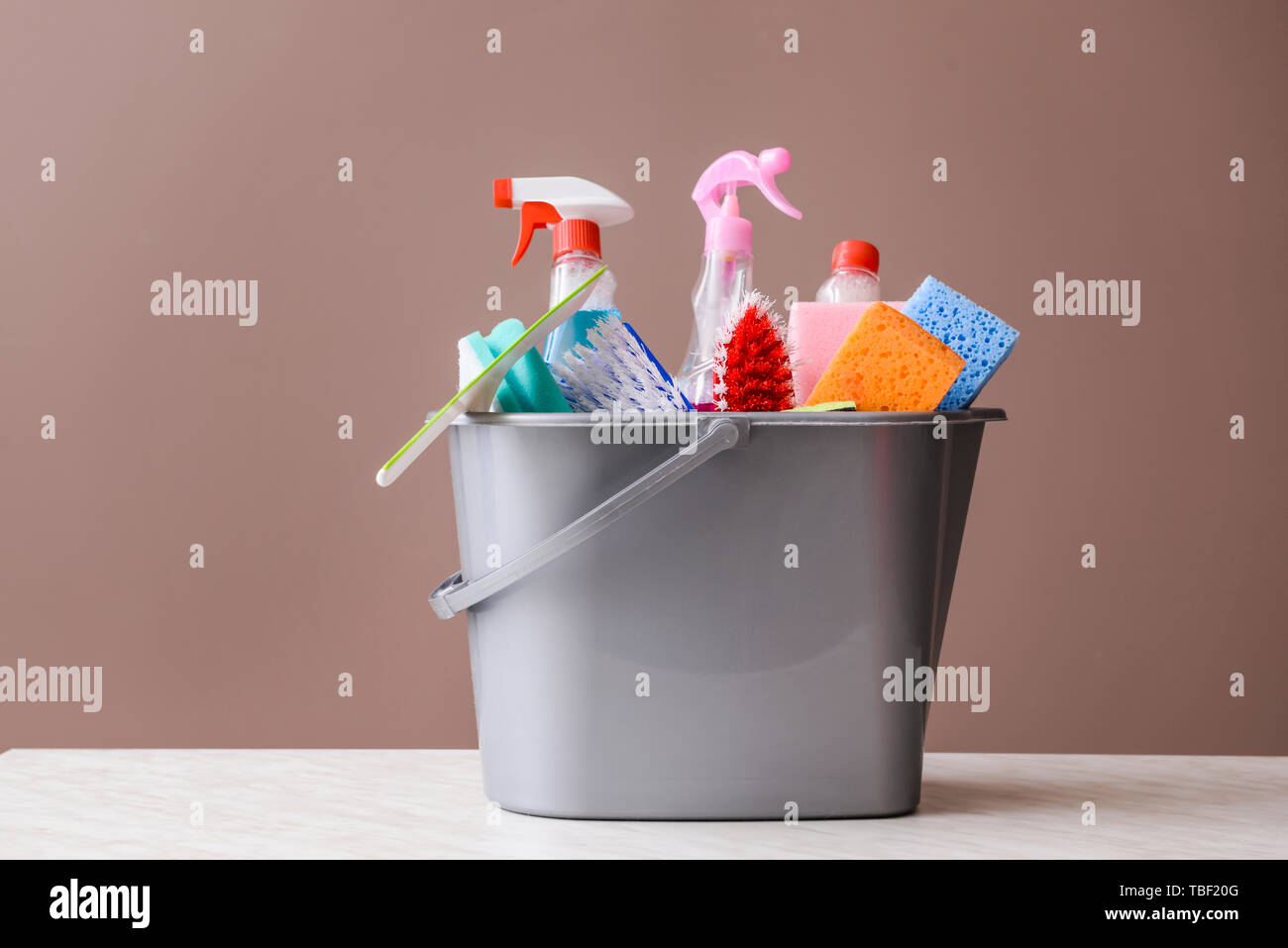 Set of cleaning supplies on table against color background Stock Photo ...