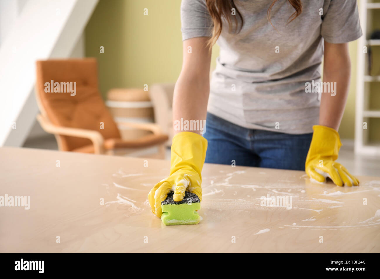 Woman cleaning table in room Stock Photo - Alamy
