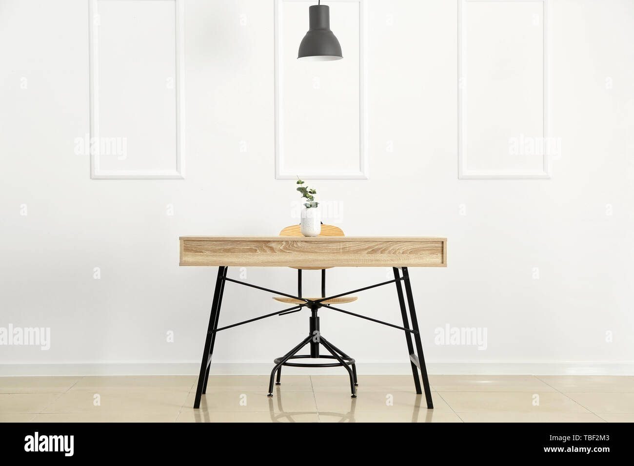 Wooden table near white wall in room Stock Photo - Alamy