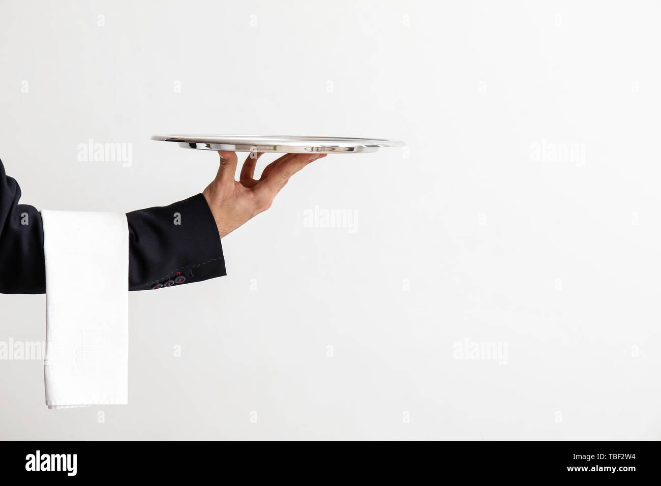 Hand of waiter with empty tray on light background Stock Photo - Alamy