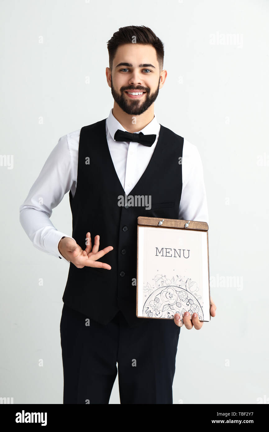 Waiter with menu on light background Stock Photo - Alamy