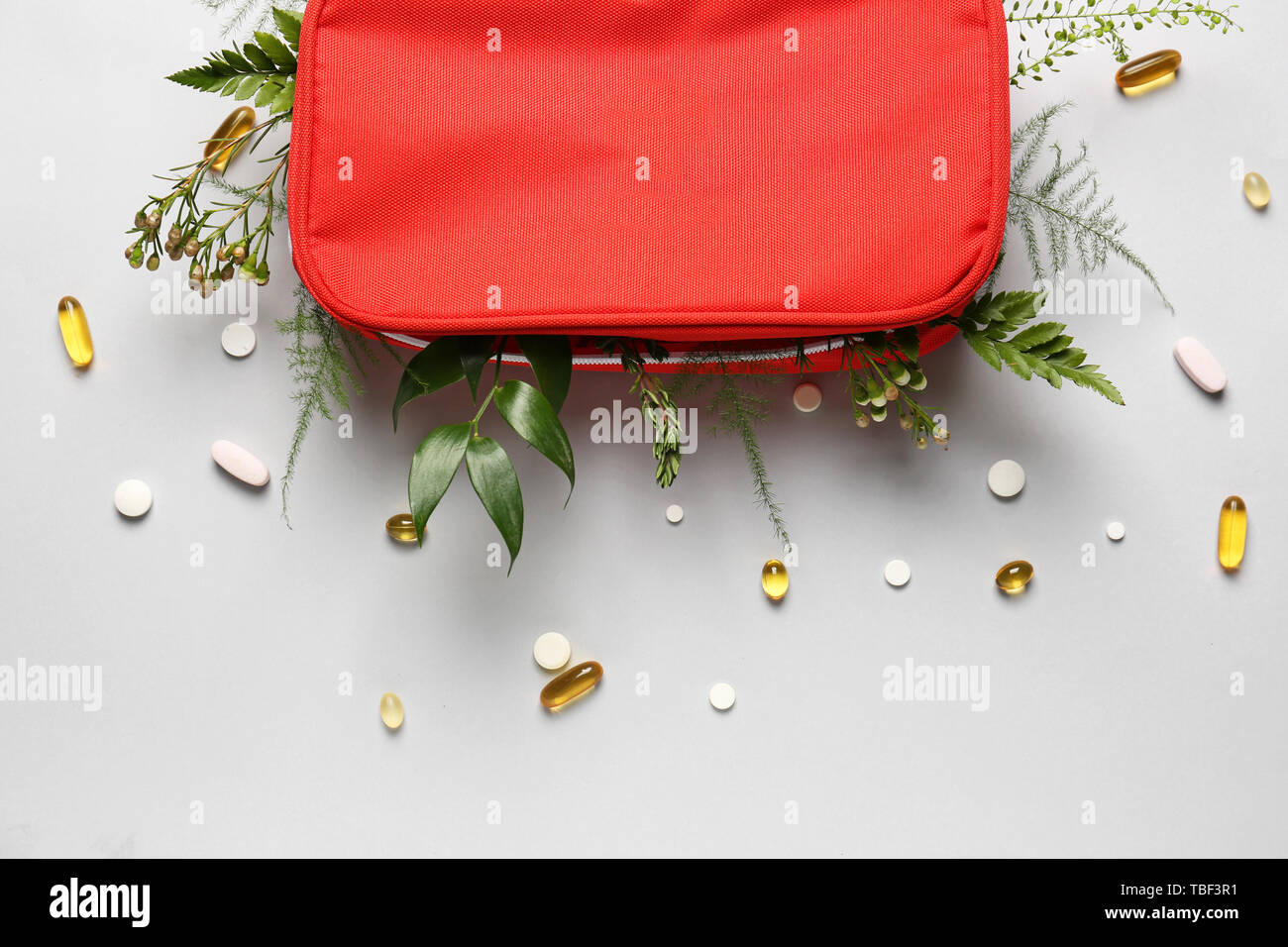 First aid kit with herbs and pills on light background Stock Photo - Alamy