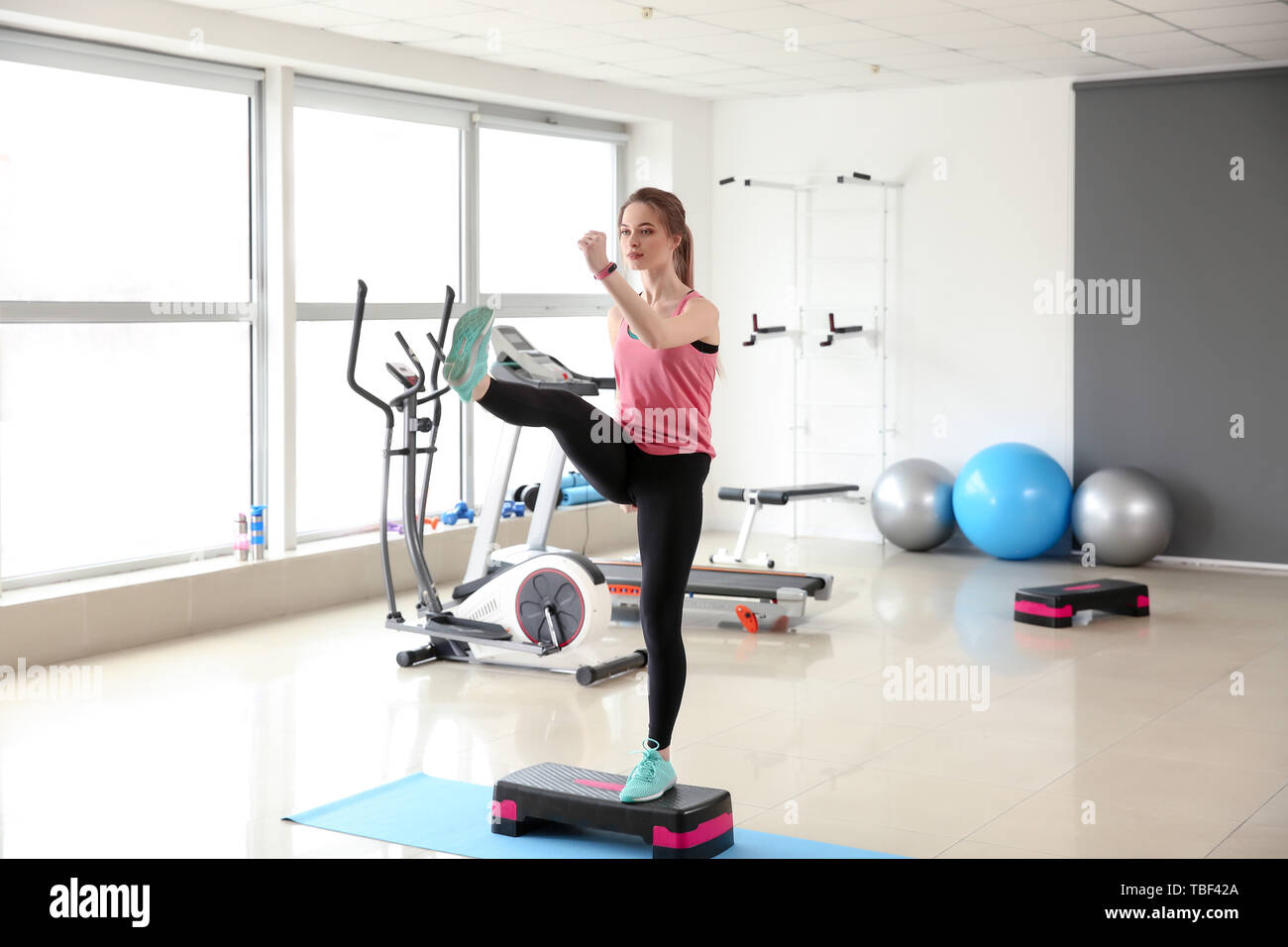 Sporty young woman training with stepper in gym Stock Photo - Alamy