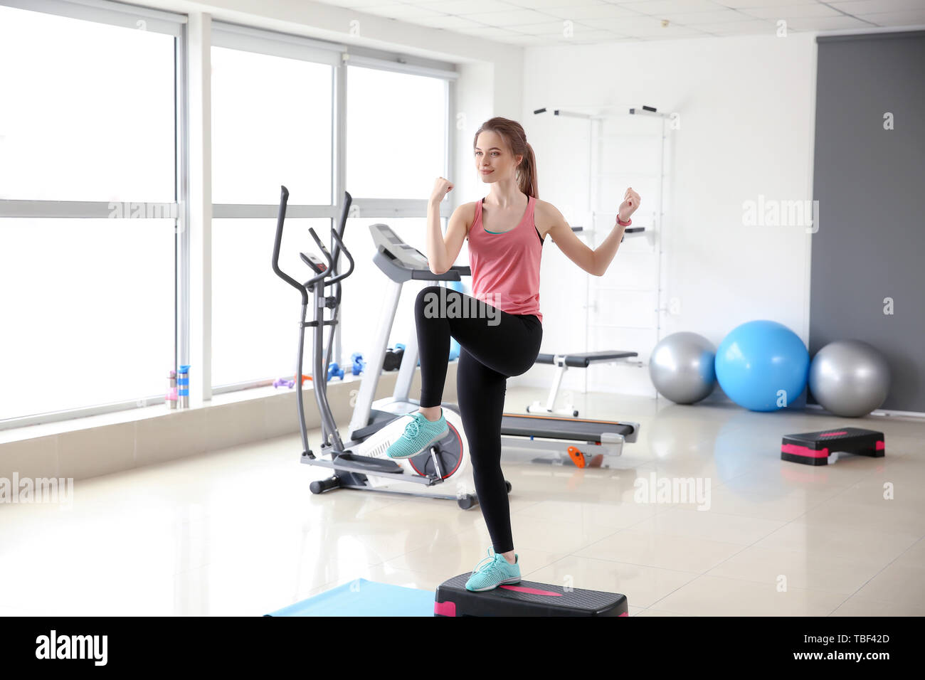 Sporty young woman training with stepper in gym Stock Photo - Alamy