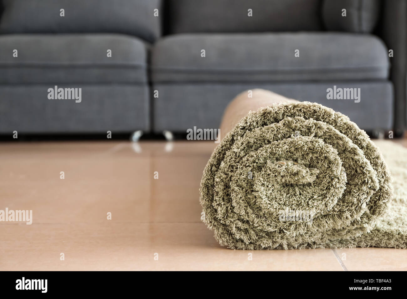 Rolled carpet on floor in room Stock Photo - Alamy