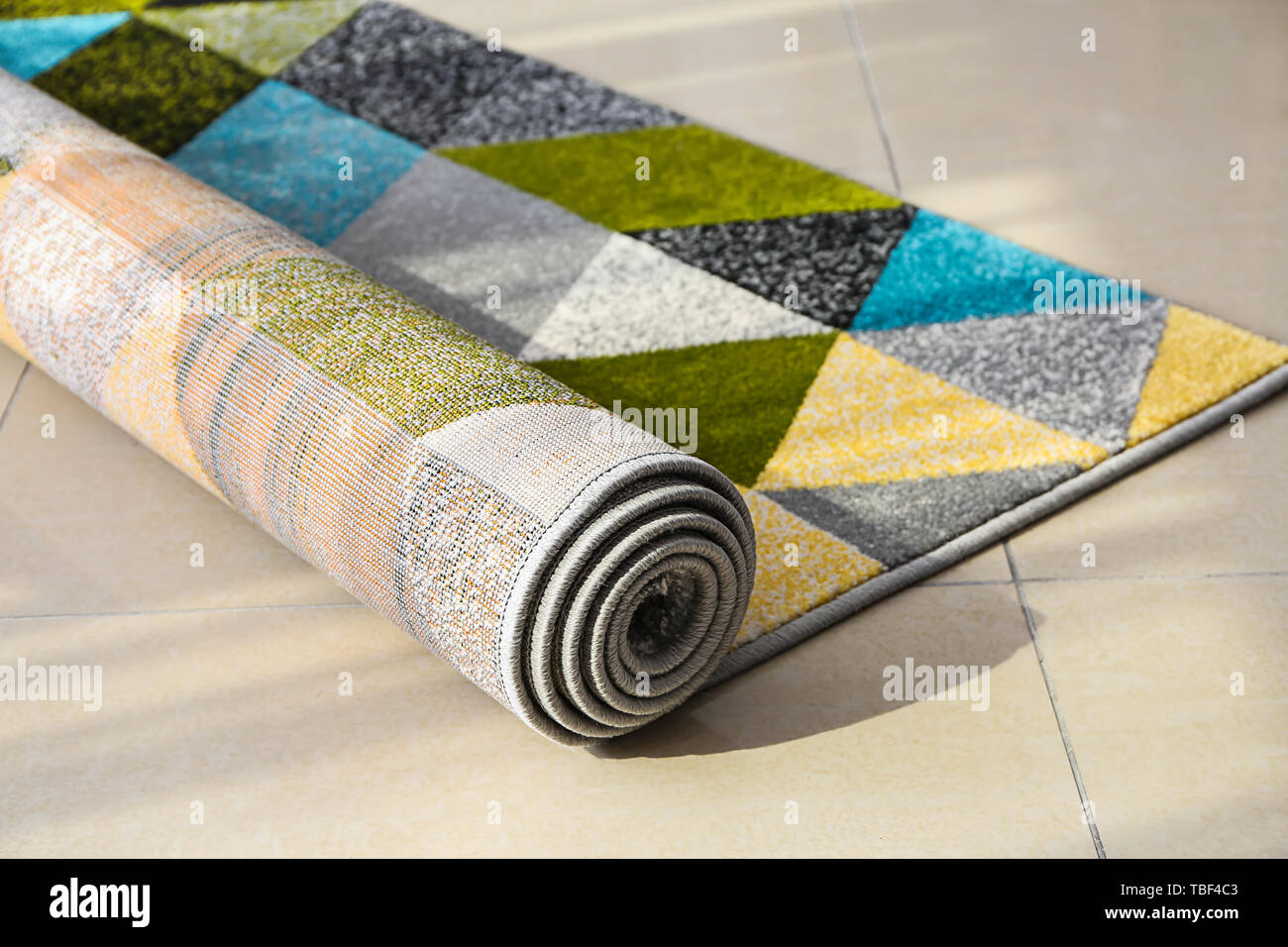 Rolled carpet on floor in room Stock Photo - Alamy