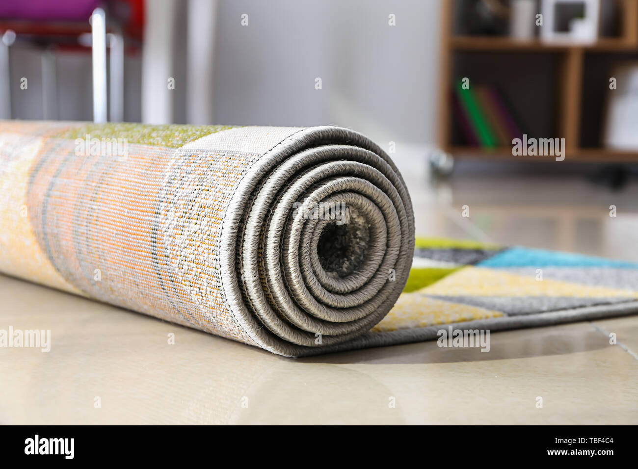Rolled carpet on floor in room Stock Photo - Alamy