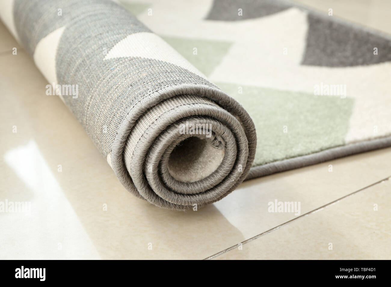 Rolled carpet on floor in room Stock Photo - Alamy