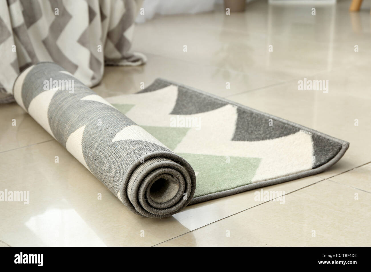 Rolled carpet on floor in room Stock Photo - Alamy