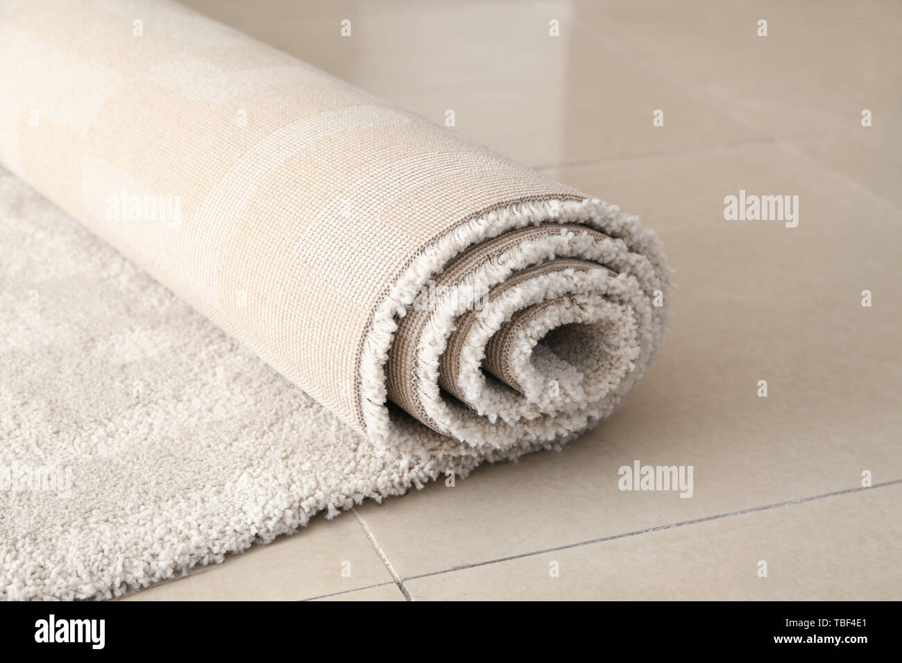 Rolled carpet on floor in room Stock Photo - Alamy