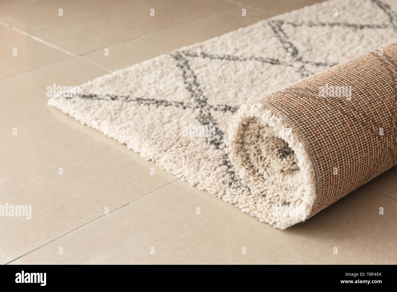 Rolled carpet on floor in room Stock Photo - Alamy