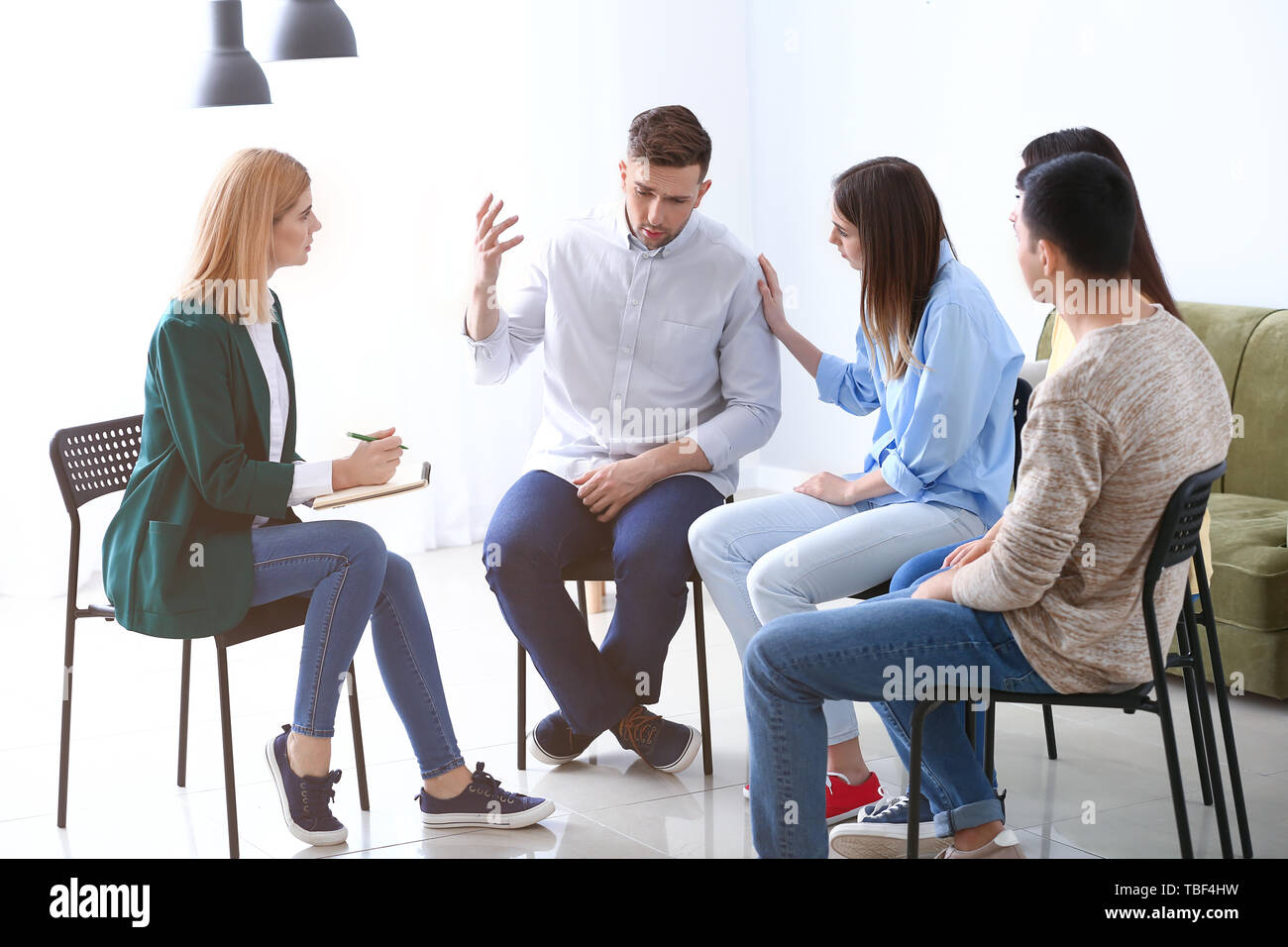 People calming man at group therapy session Stock Photo - Alamy