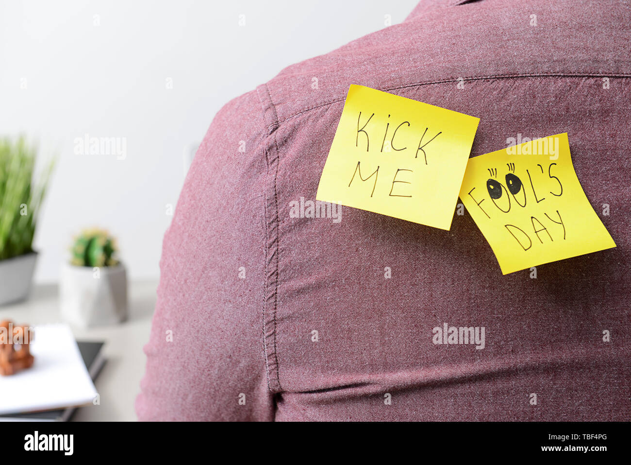 Sticky notes on back of young man, closeup. April Fool's Day prank ...