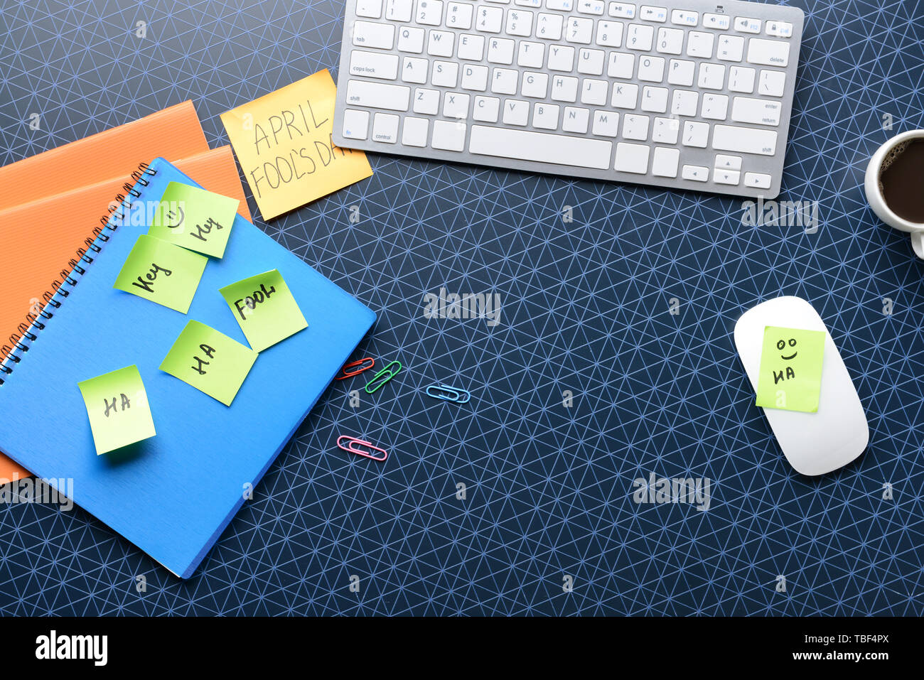 Computer keyboard with stationery and sticky notes on color background ...