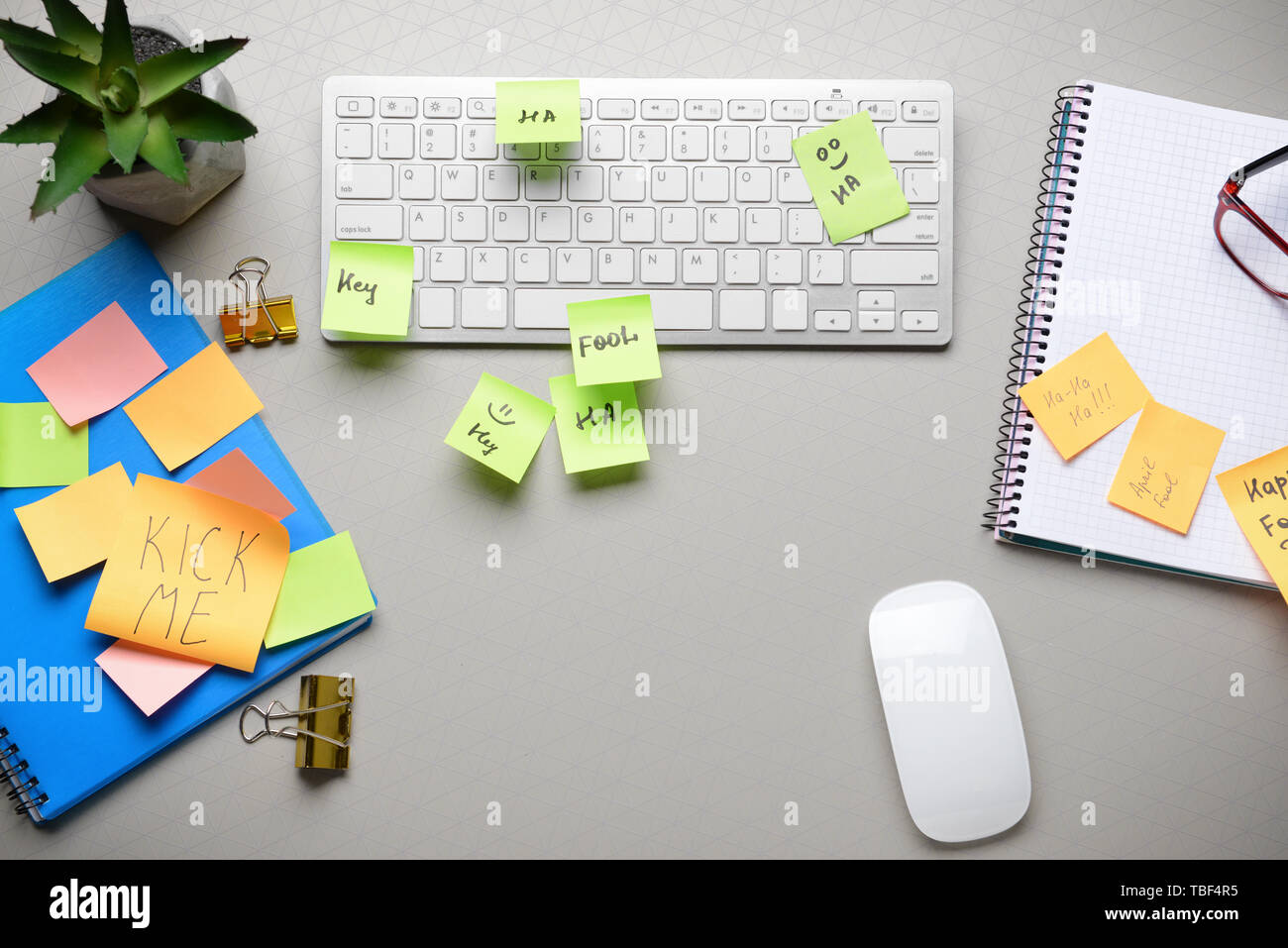 Computer keyboard with stationery and sticky notes on grey background ...