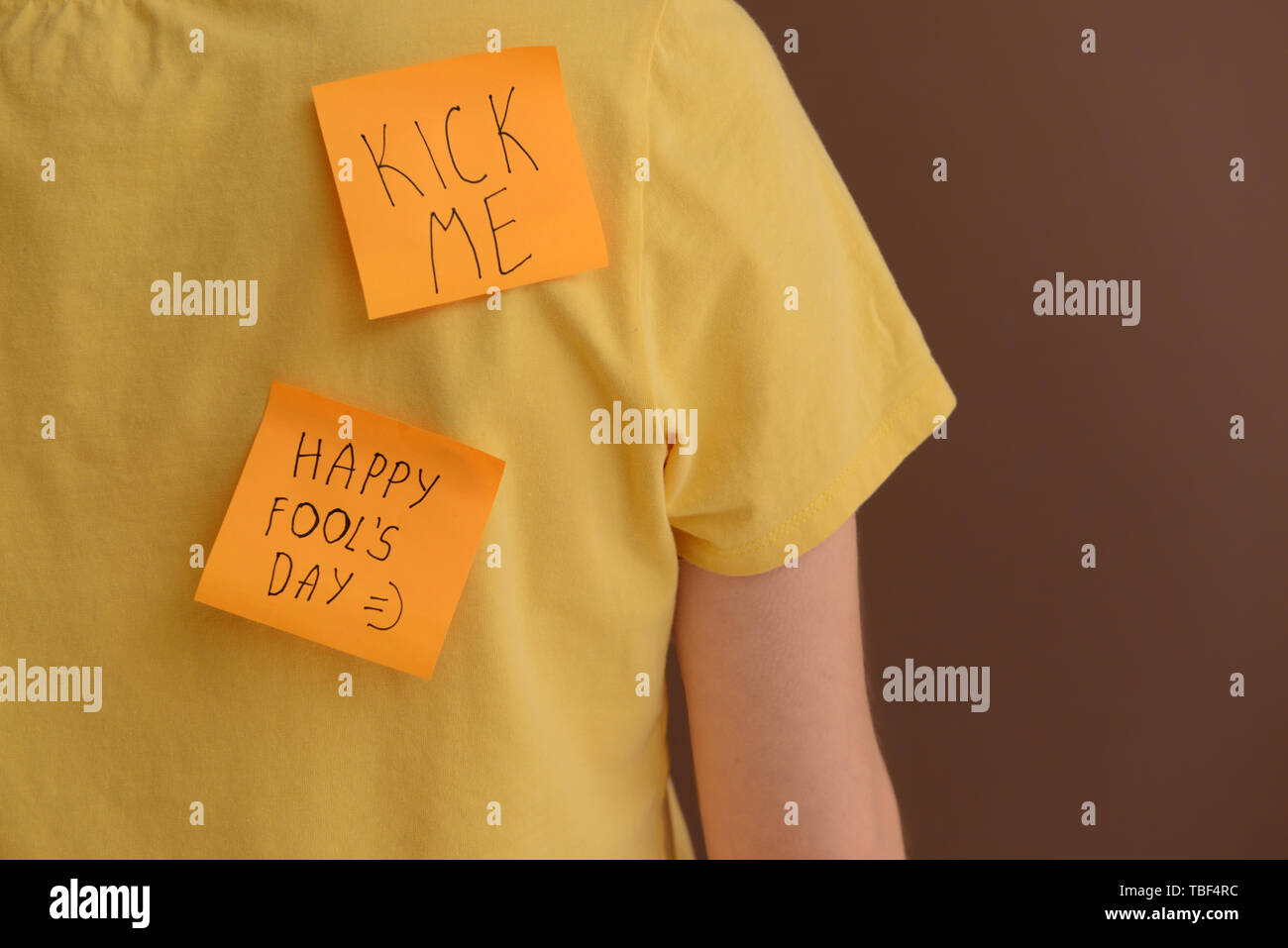 Sticky notes on back of young woman against color background. April ...