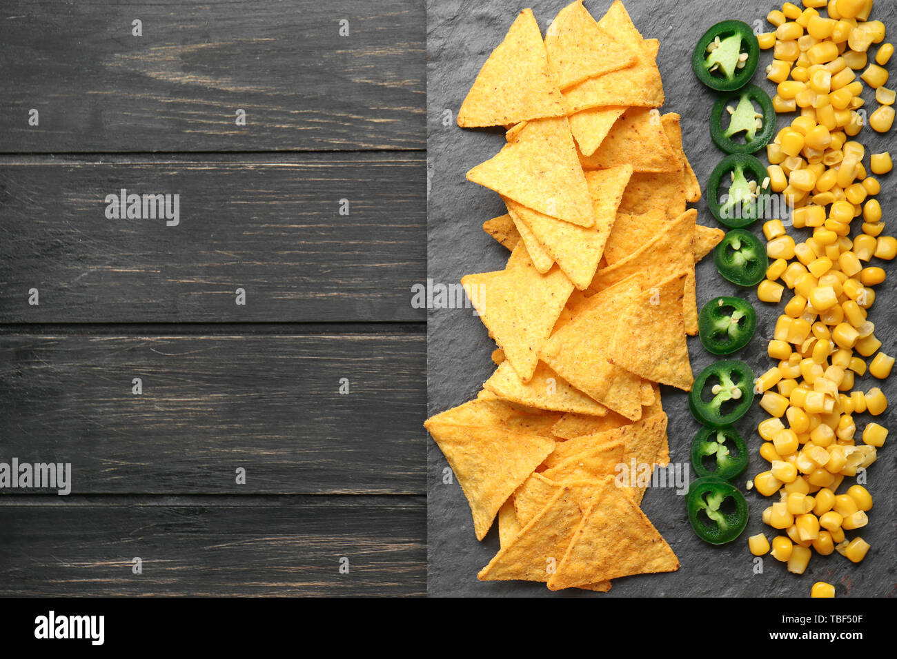Stand with tasty nachos, jalapeno and corn on table Stock Photo - Alamy