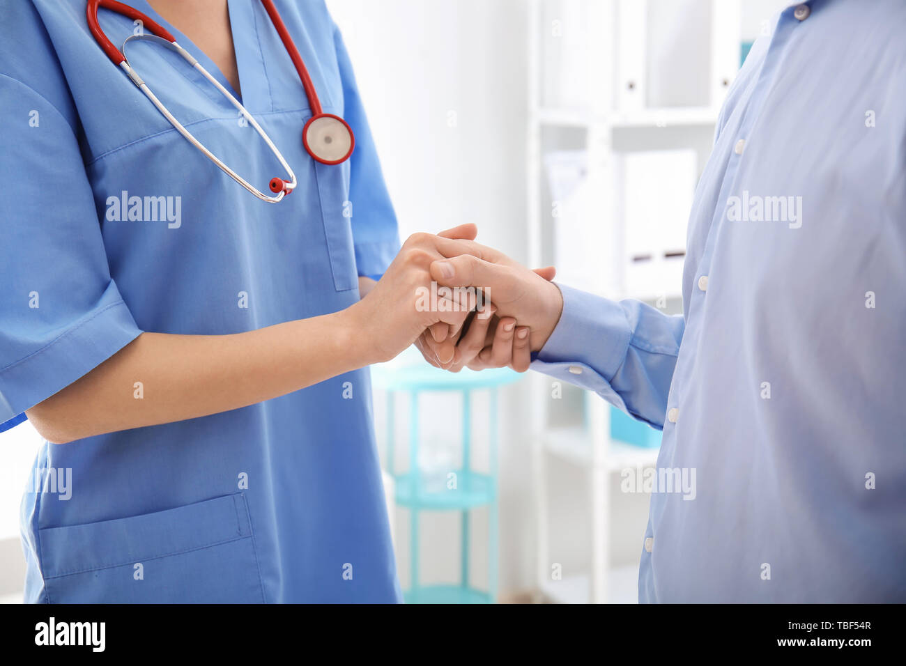 Female doctor comforting her patient in clinic Stock Photo - Alamy