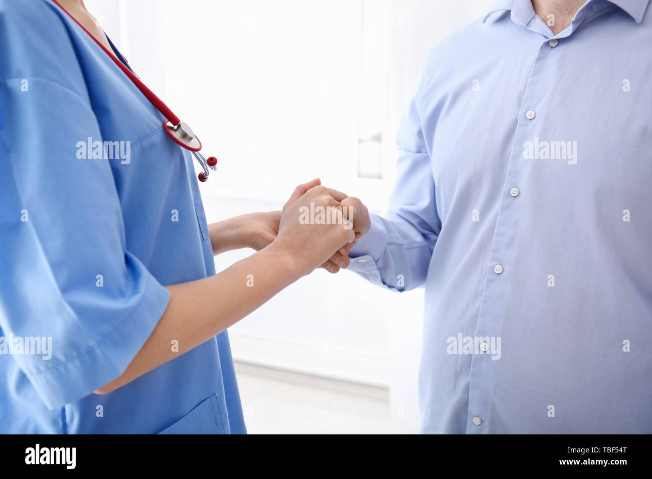 Female doctor comforting her patient in clinic Stock Photo - Alamy