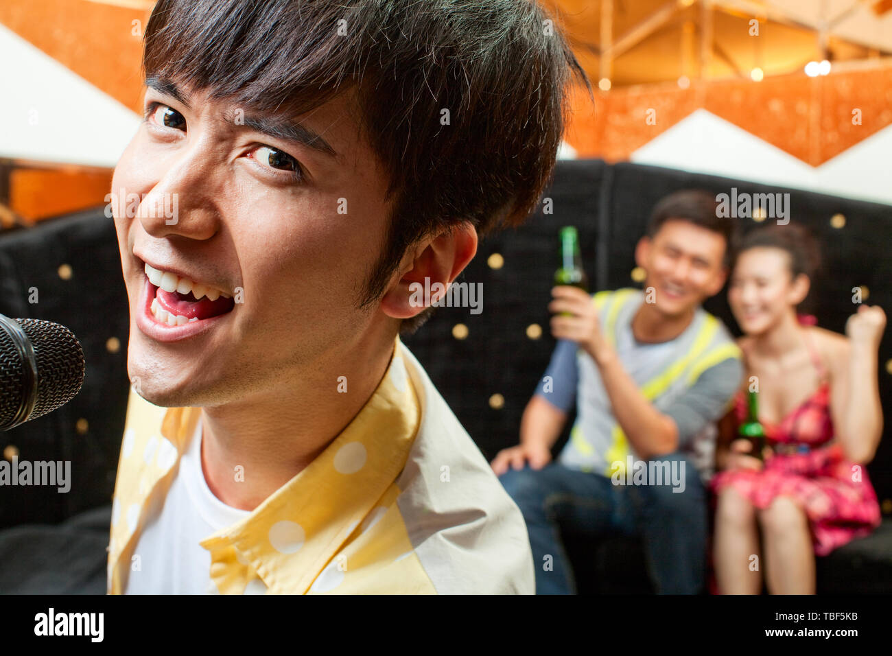 Three friends sing at KTV party Stock Photo - Alamy
