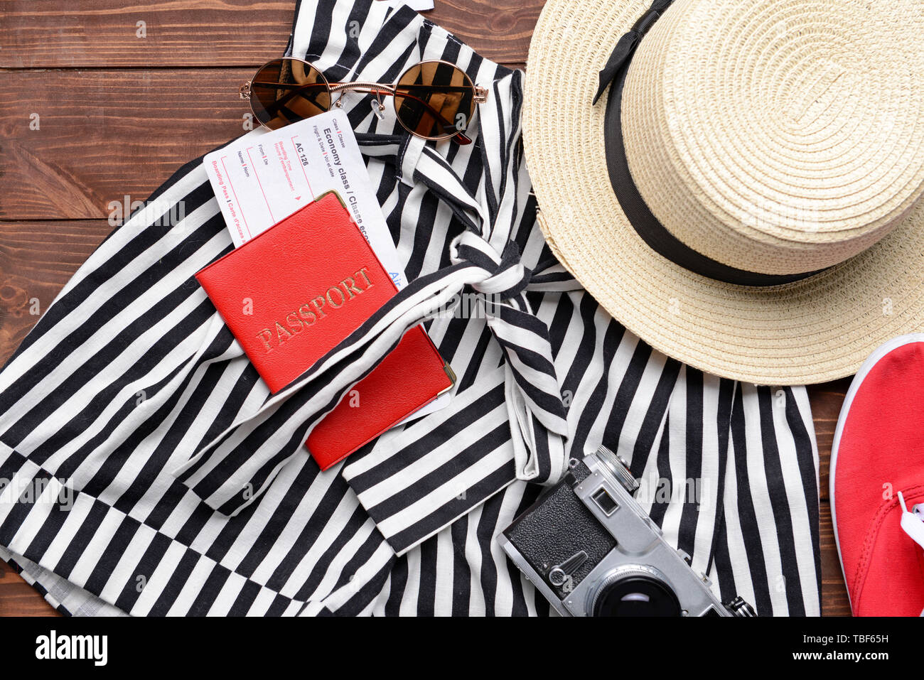 Female clothes with documents and photo camera on wooden background ...
