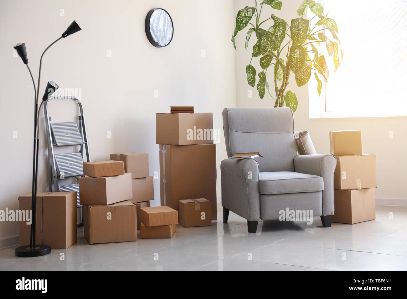 Furniture with moving boxes in room Stock Photo - Alamy