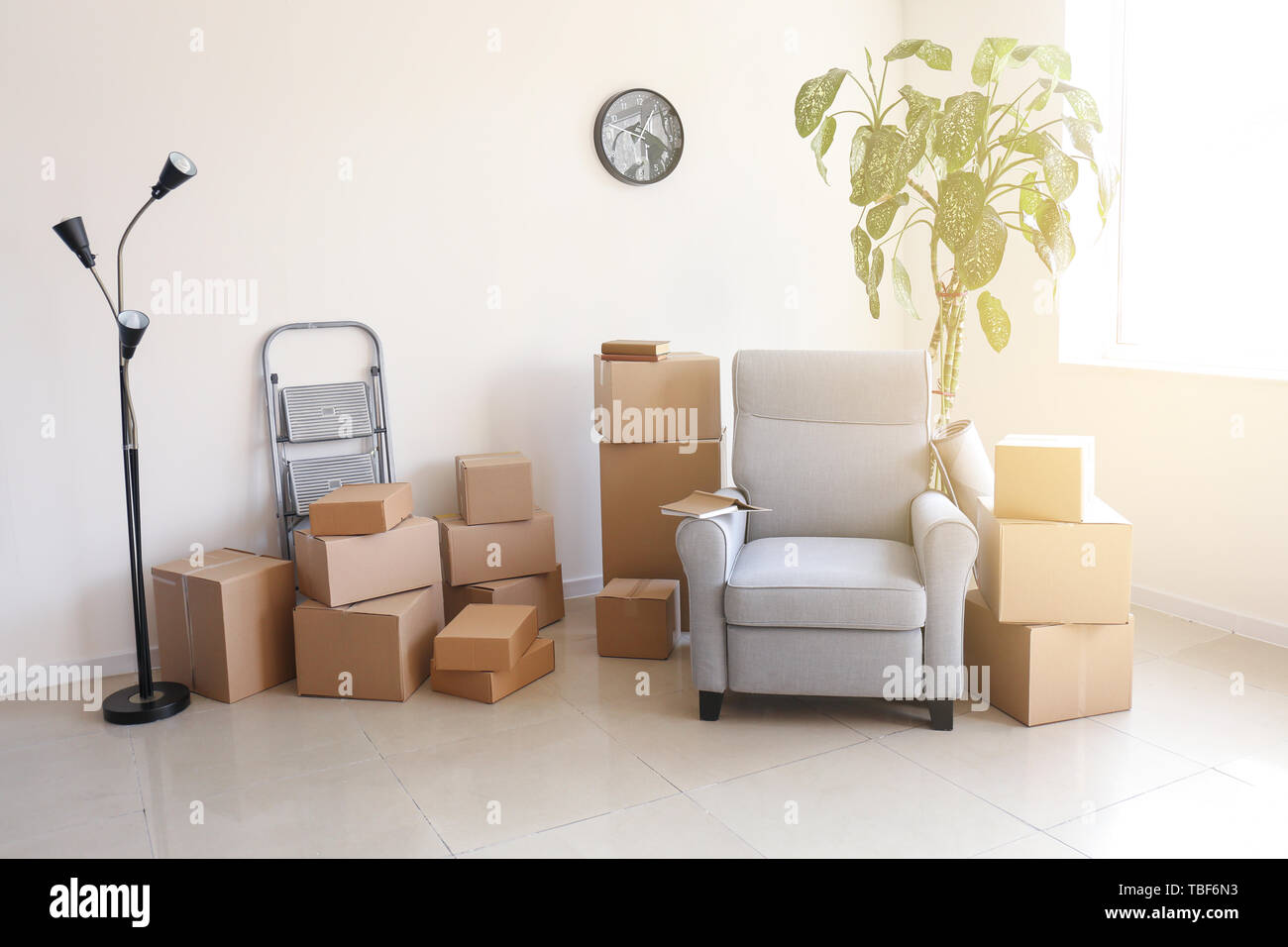 Furniture with moving boxes in room Stock Photo - Alamy