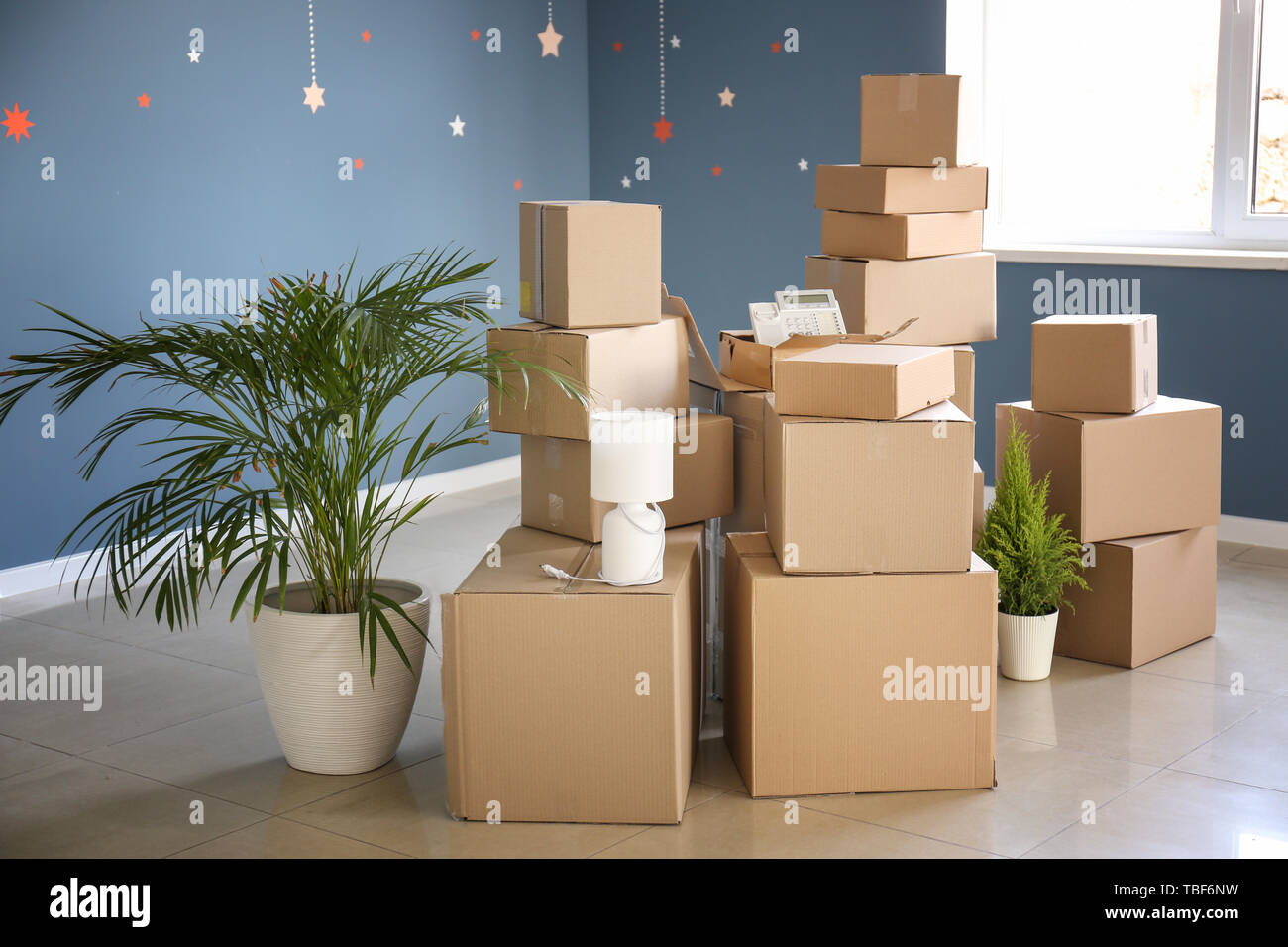 Moving boxes with belongings in empty room Stock Photo - Alamy
