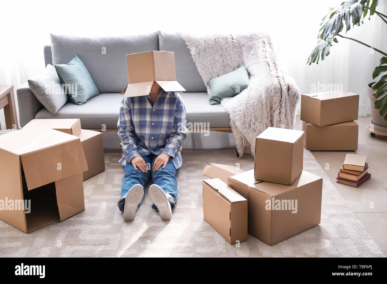 Funny woman with moving boxes in room Stock Photo - Alamy