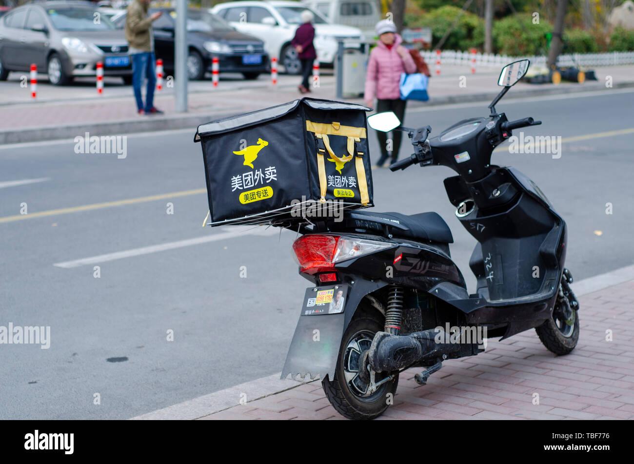 A Meituan takeout motorcycle parked on the side of the road Stock Photo ...