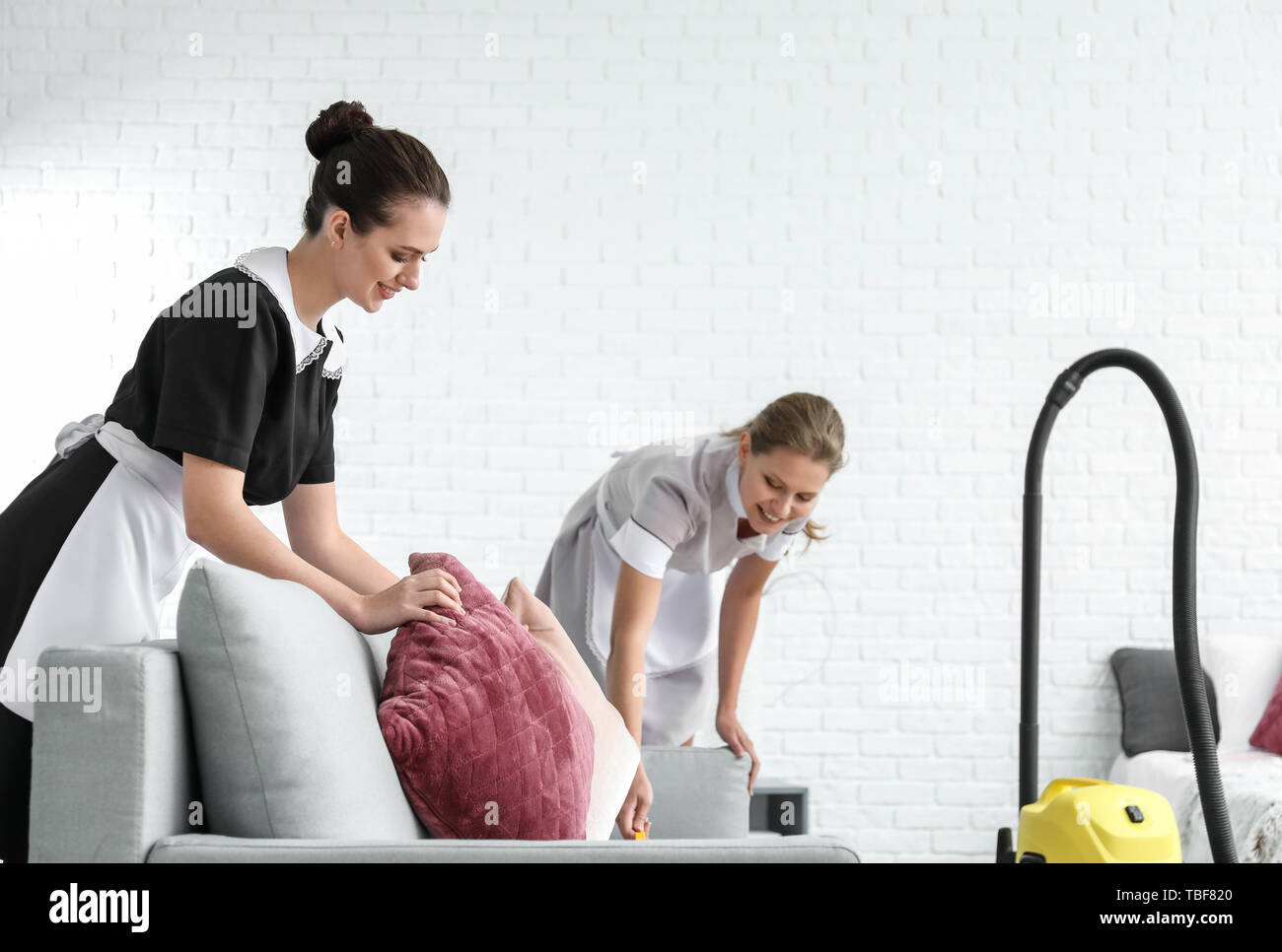 Beautiful female housekeepers working in room Stock Photo - Alamy