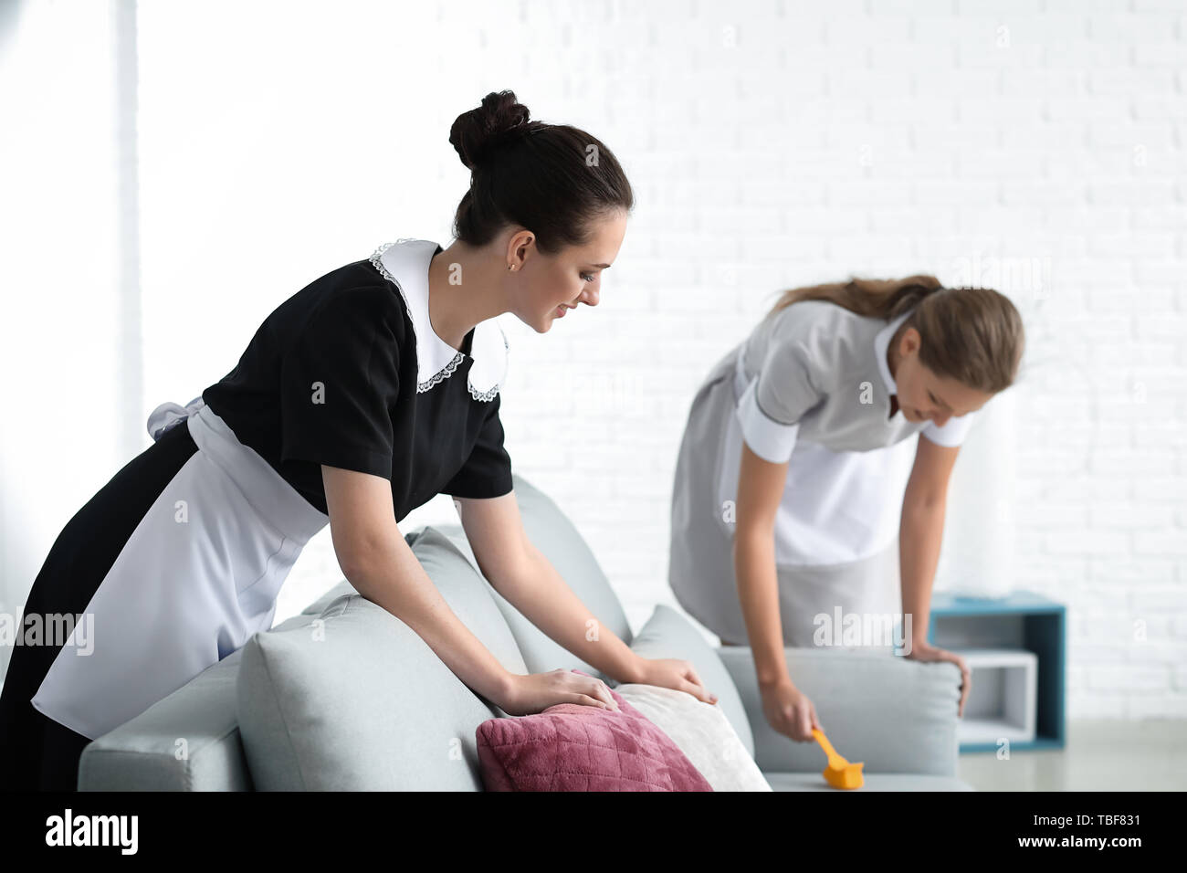 Beautiful female housekeepers working in room Stock Photo - Alamy