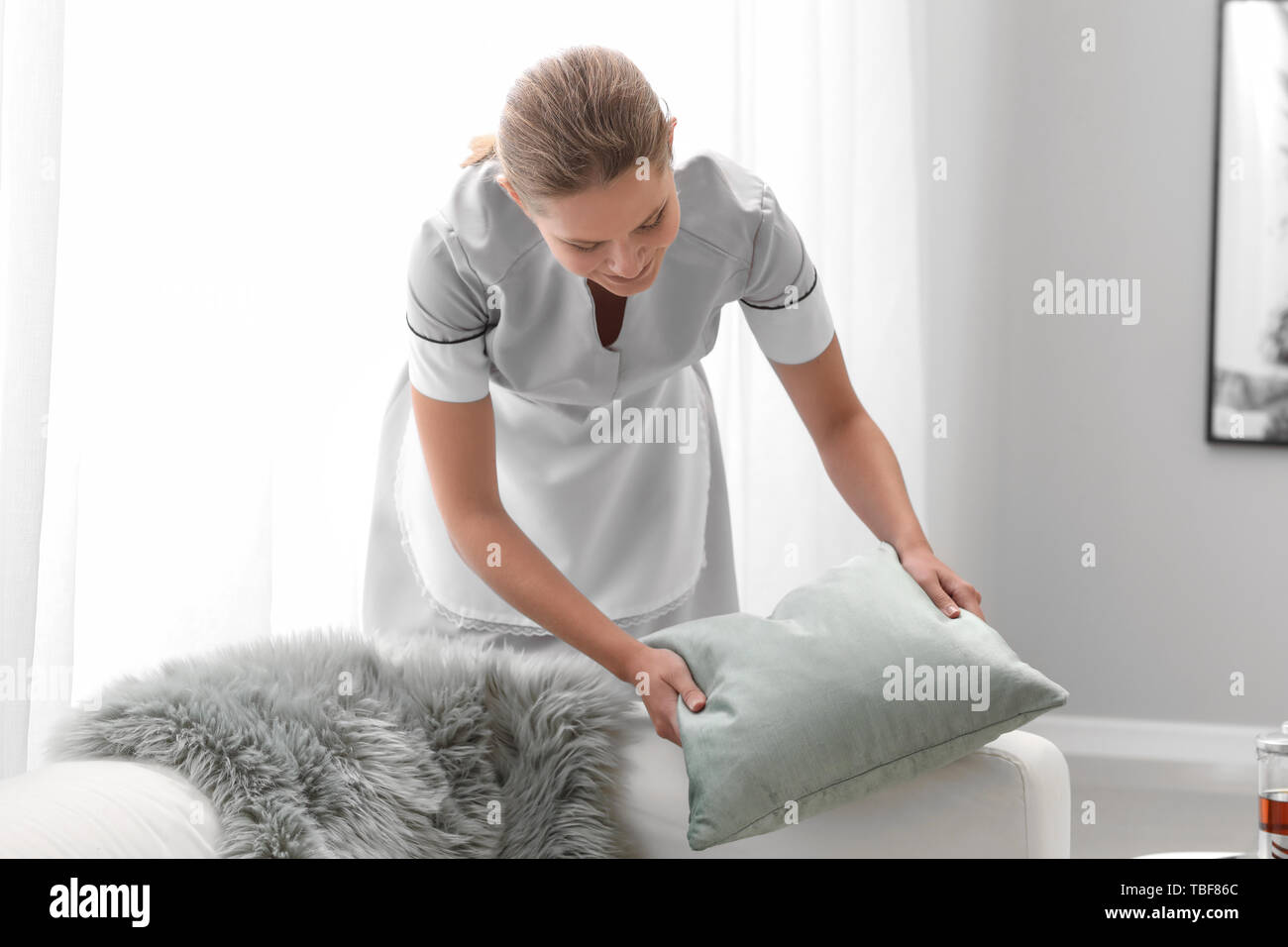 Beautiful female housekeeper working in room Stock Photo - Alamy