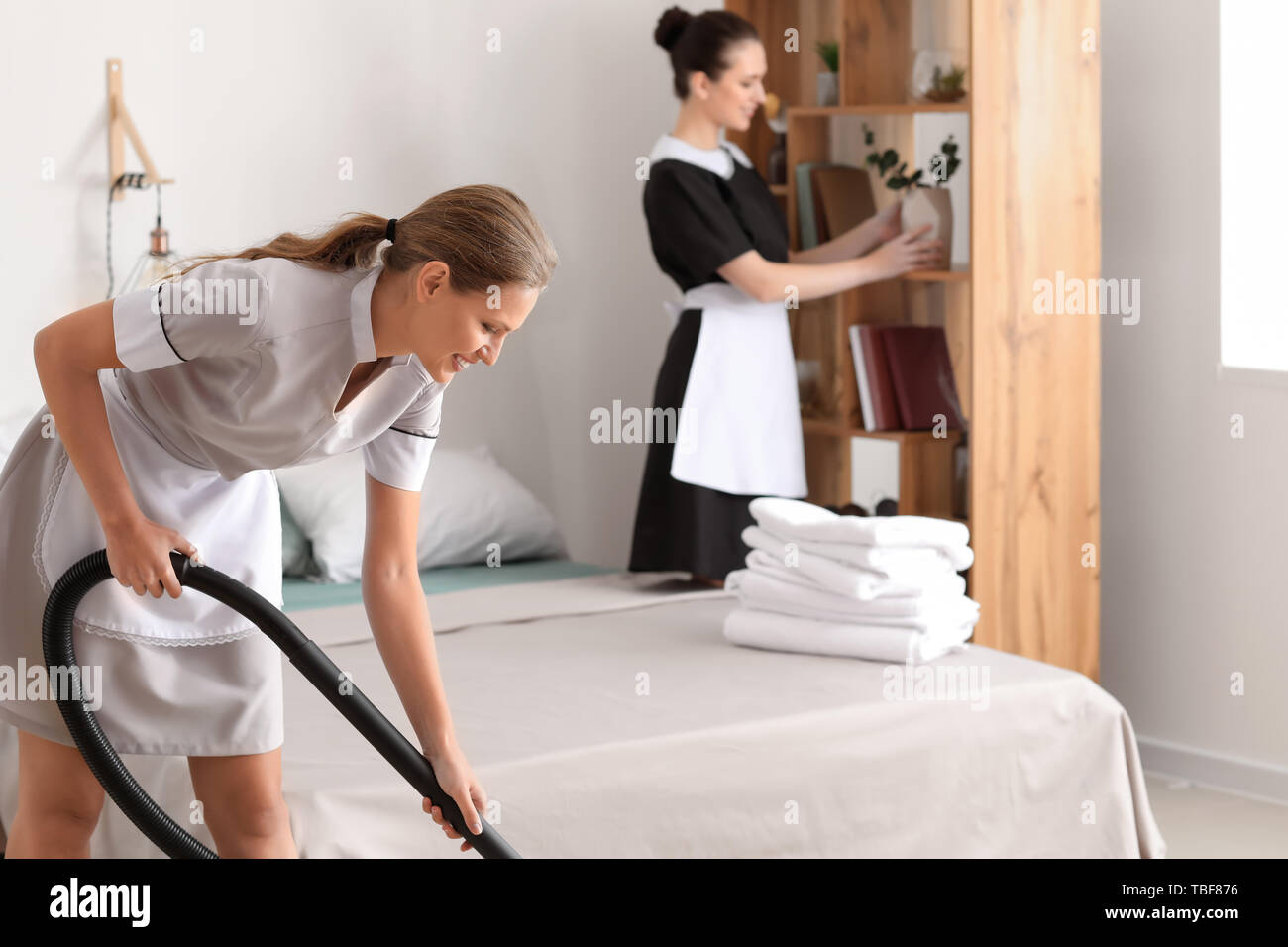 Beautiful female housekeepers working in room Stock Photo - Alamy