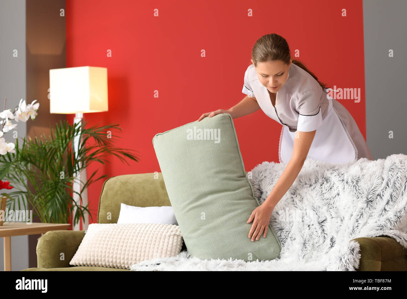 Beautiful female housekeeper working in room Stock Photo - Alamy