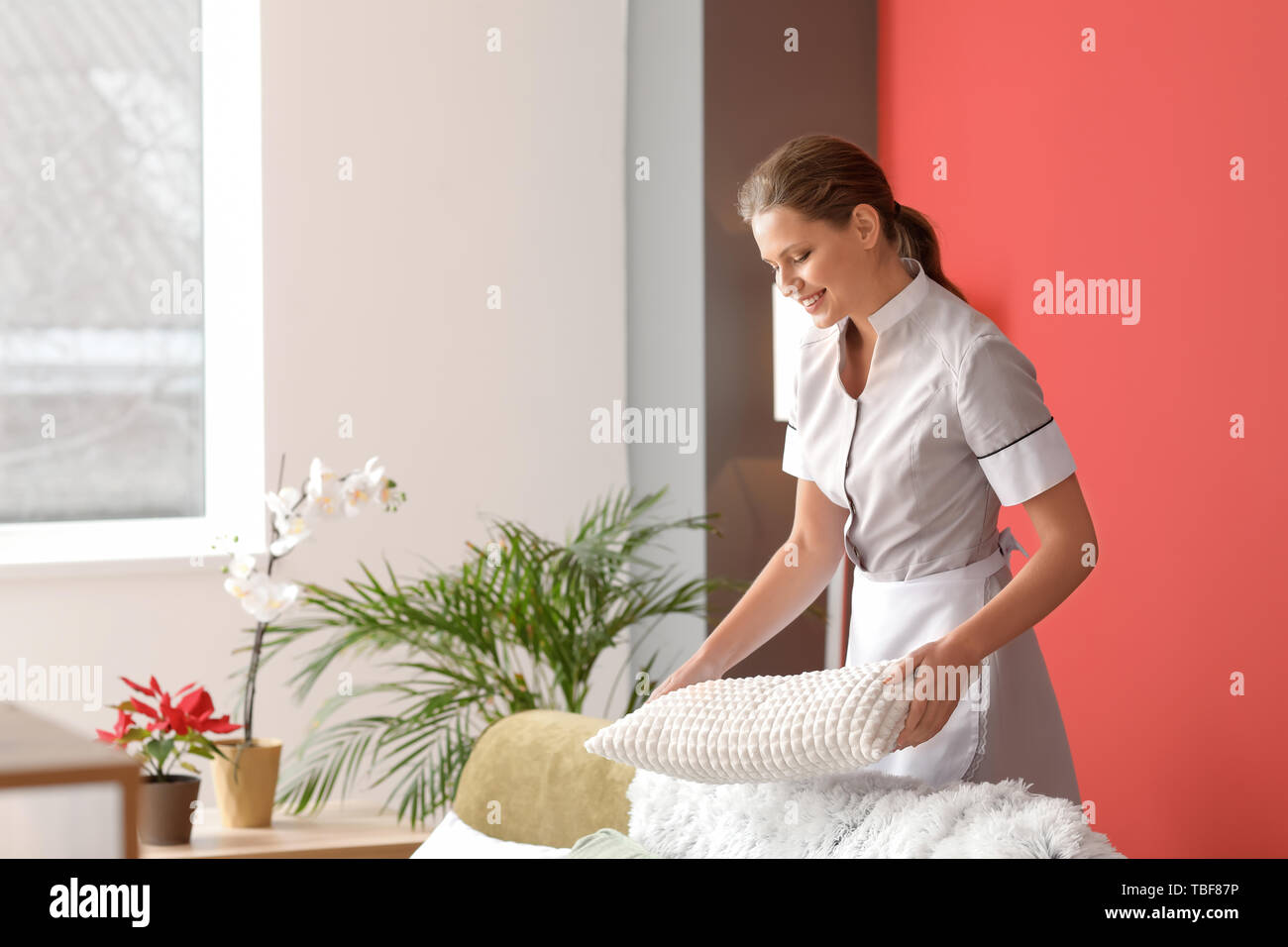 Beautiful female housekeeper working in room Stock Photo - Alamy