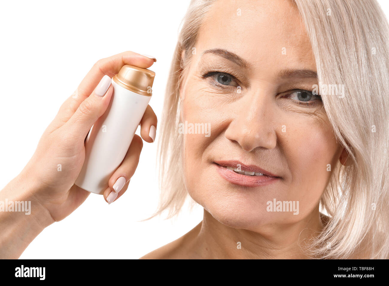 Female hand applying serum onto mature woman's face against white ...