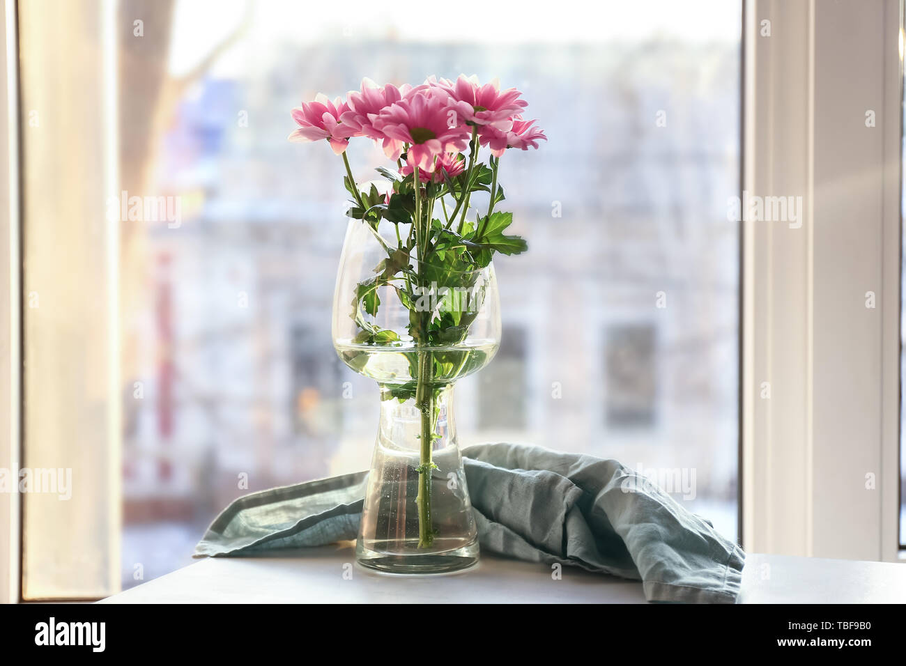 Glass vase with beautiful flowers on table near window Stock Photo - Alamy