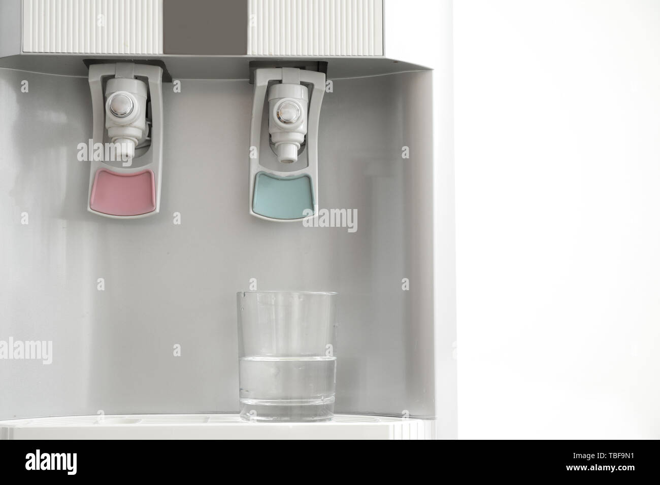 Modern cooler with glass of water, closeup Stock Photo - Alamy