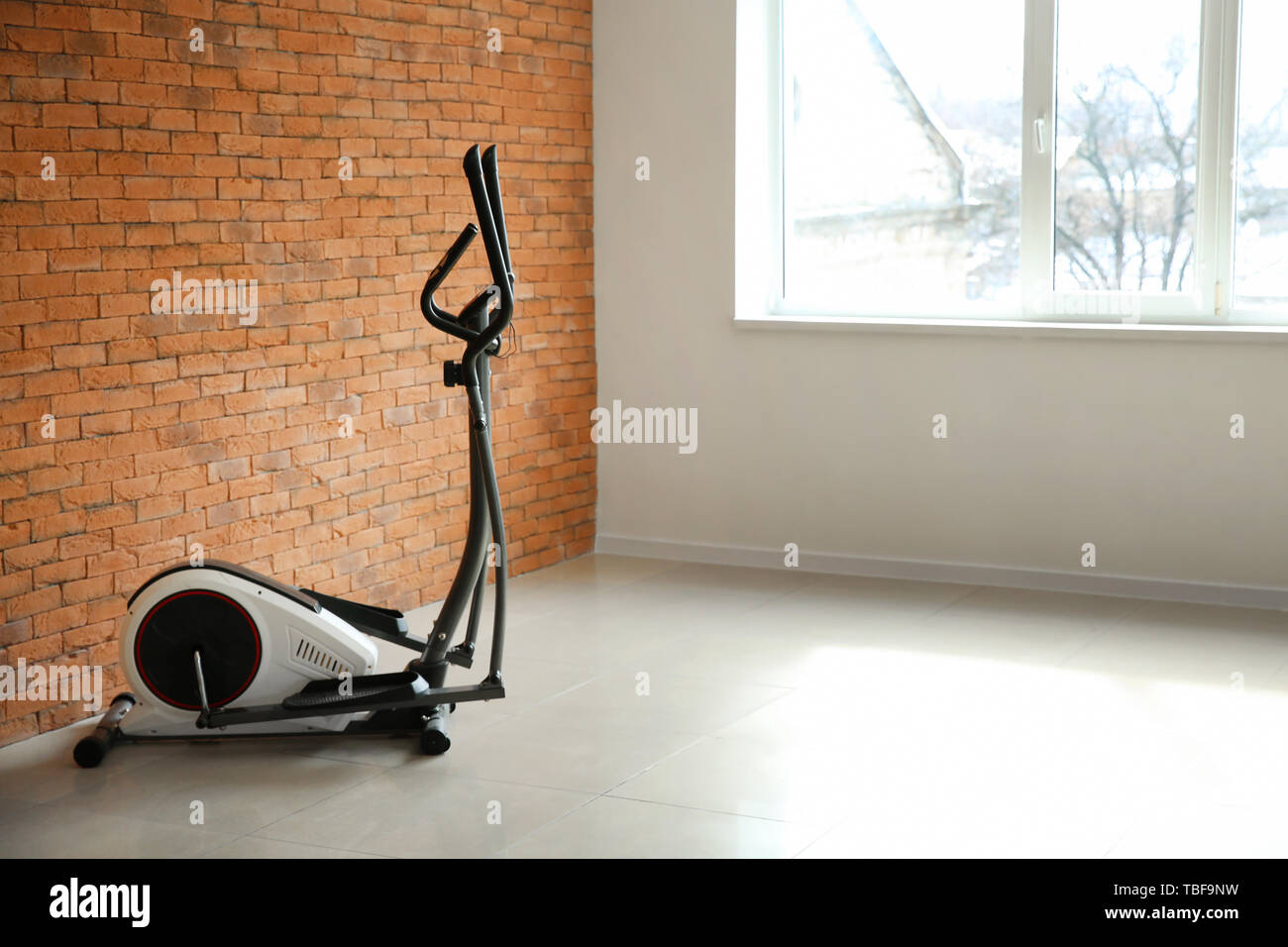 Modern exercise machine near brick wall Stock Photo - Alamy